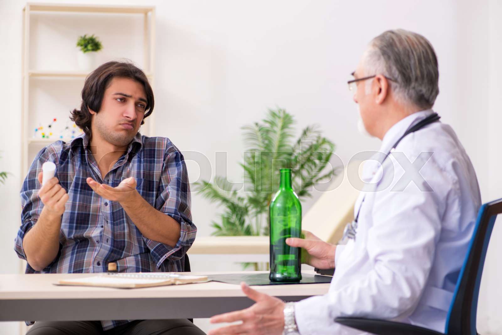 Young male alcoholic visiting old doctor | Stock image | Colourbox