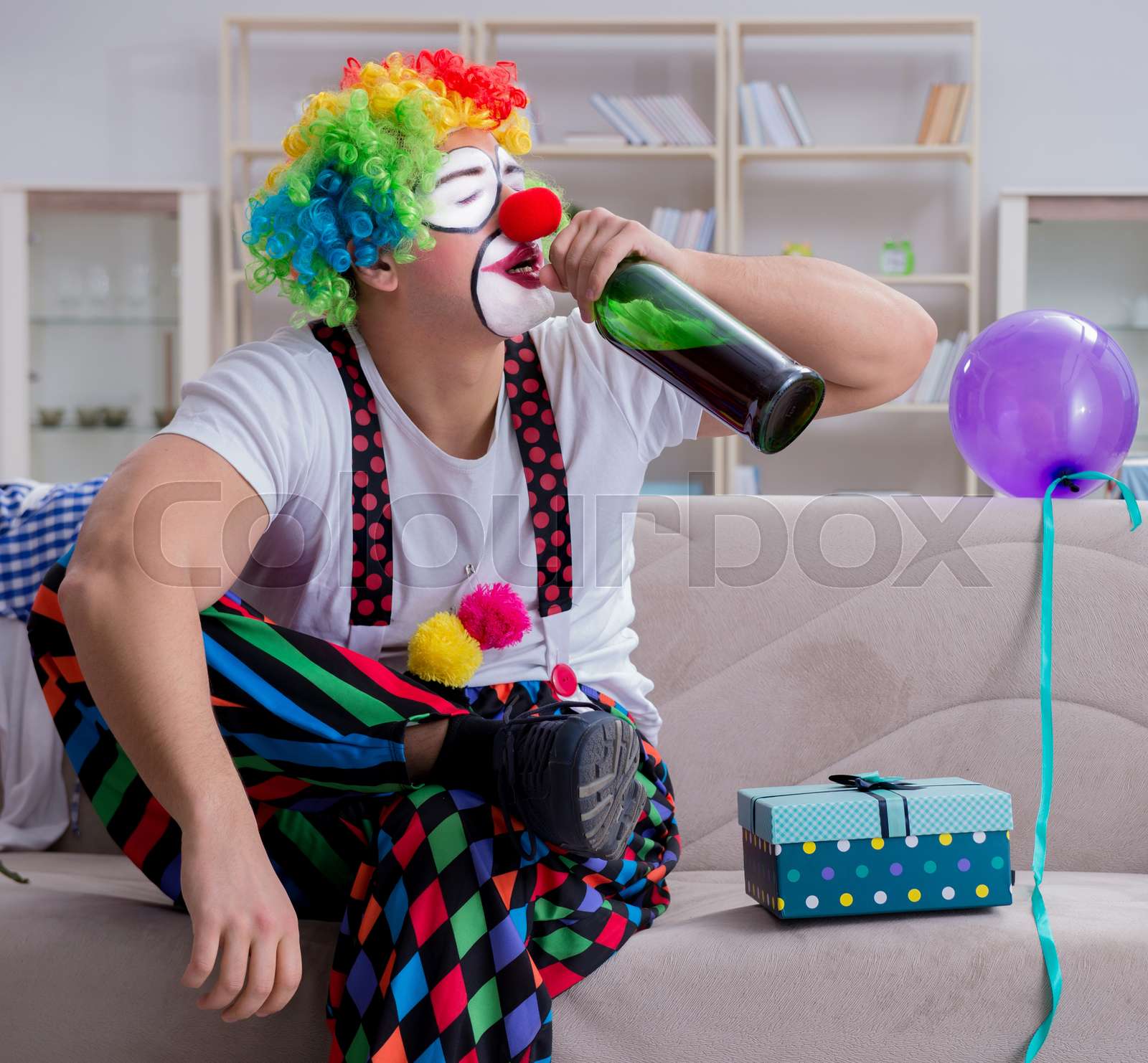 Drunk clown celebrating having a party at home | Stock image | Colourbox