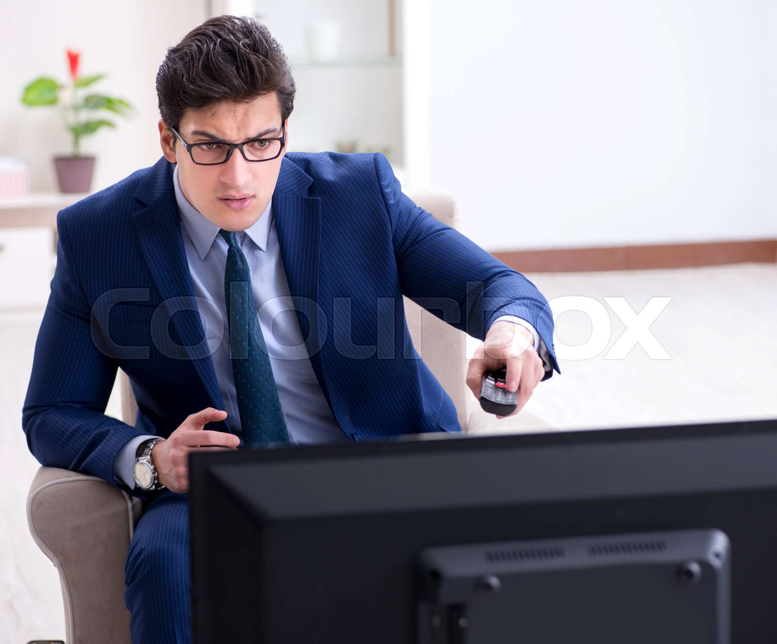 Businessman watching tv in the office | Stock image | Colourbox