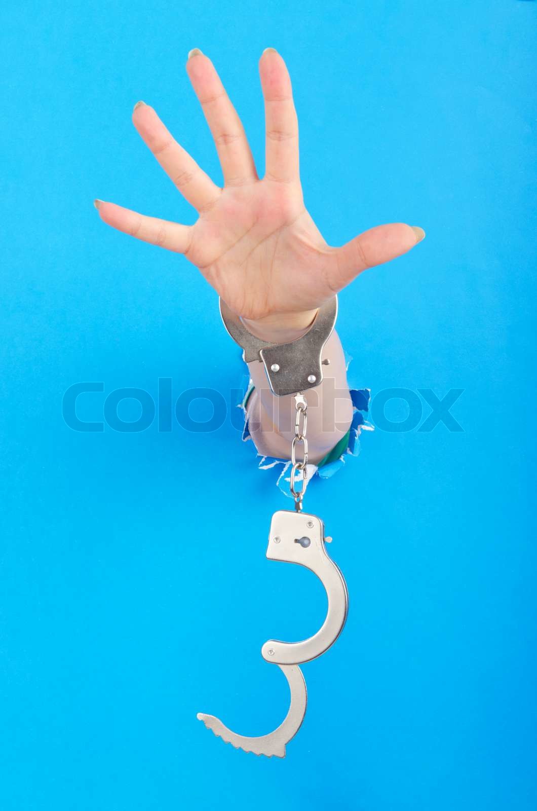 Hand with handcuffs out of paper | Stock image | Colourbox