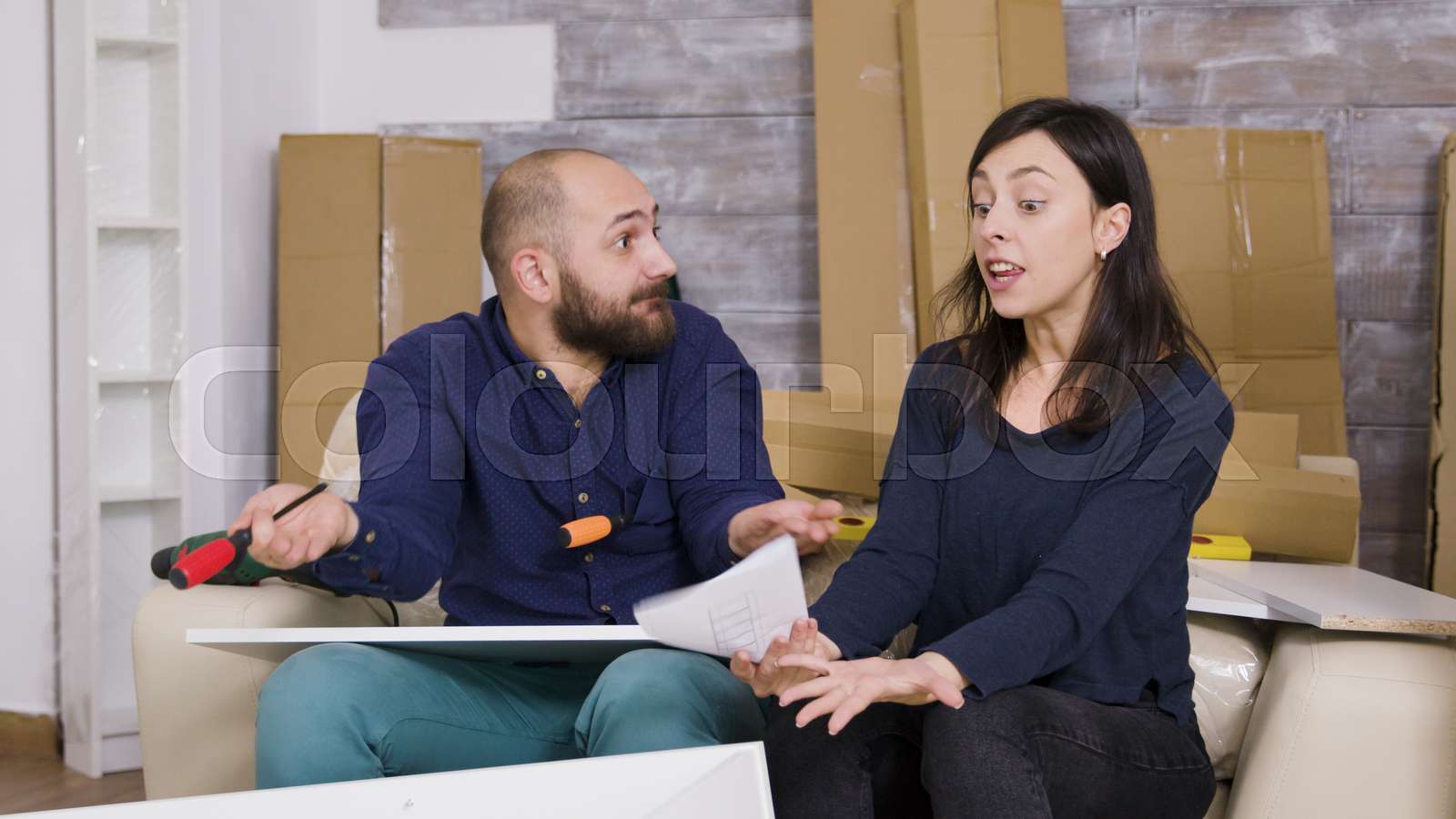 Angry girlfriend hitting boyfriend with furniture instructions | Stock ...