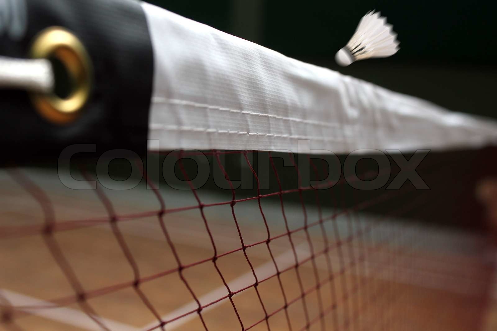 Photo of shuttle badminton net up close and a fast moving shuttlecock ...