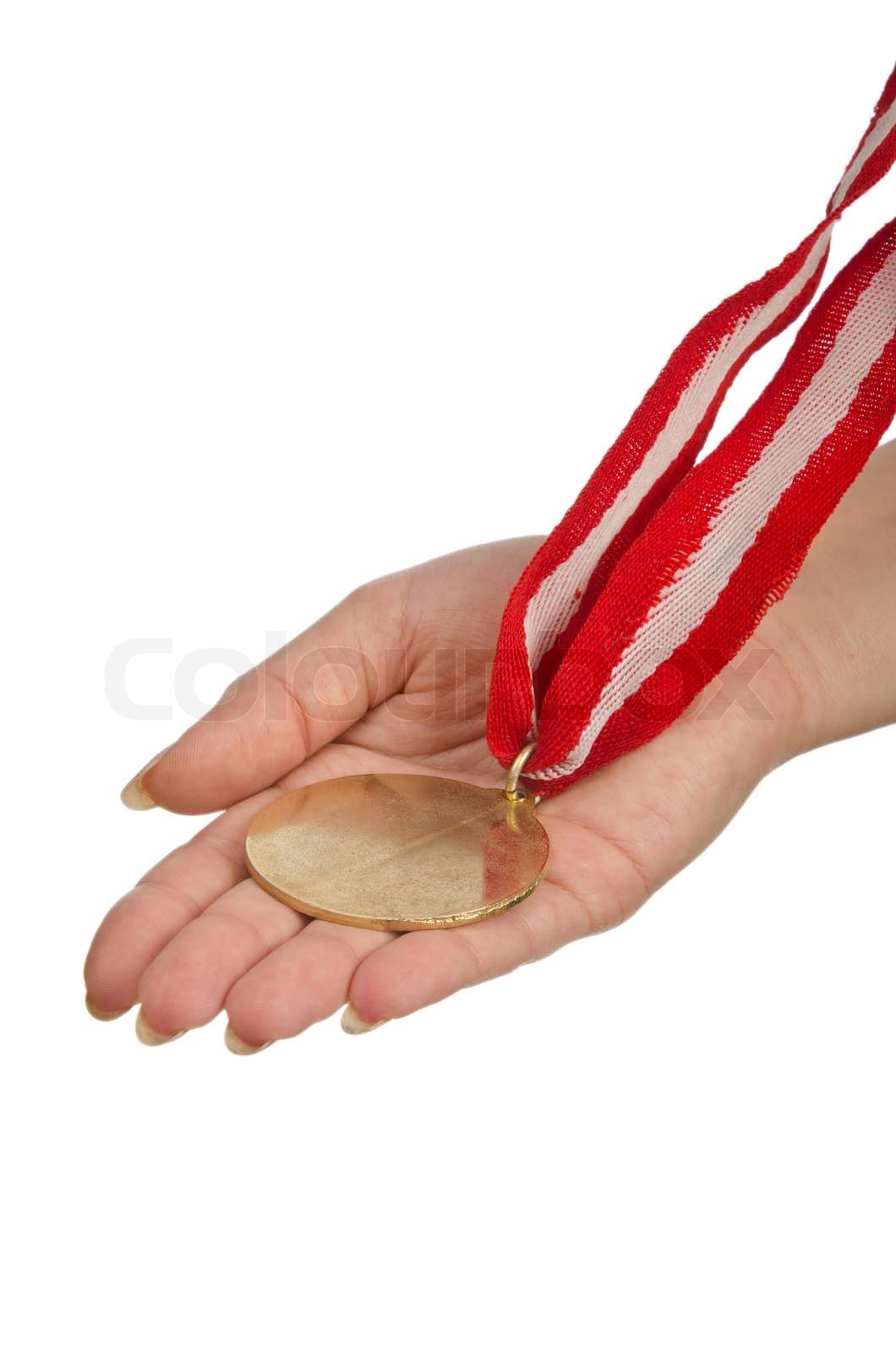 Hand holding gold medal on white | Stock image | Colourbox