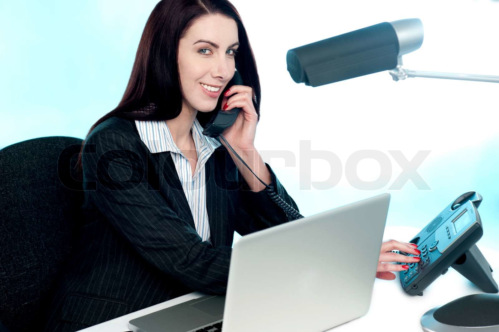 Secretary talking to client via phone call | Stock image | Colourbox