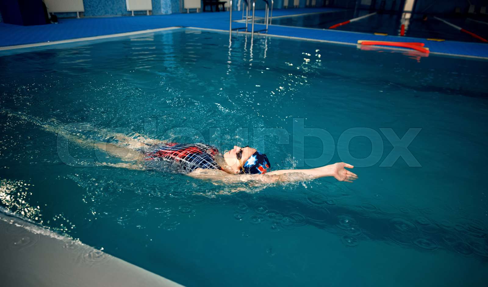 Female swimmer swimming on her back in pool | Stock image | Colourbox