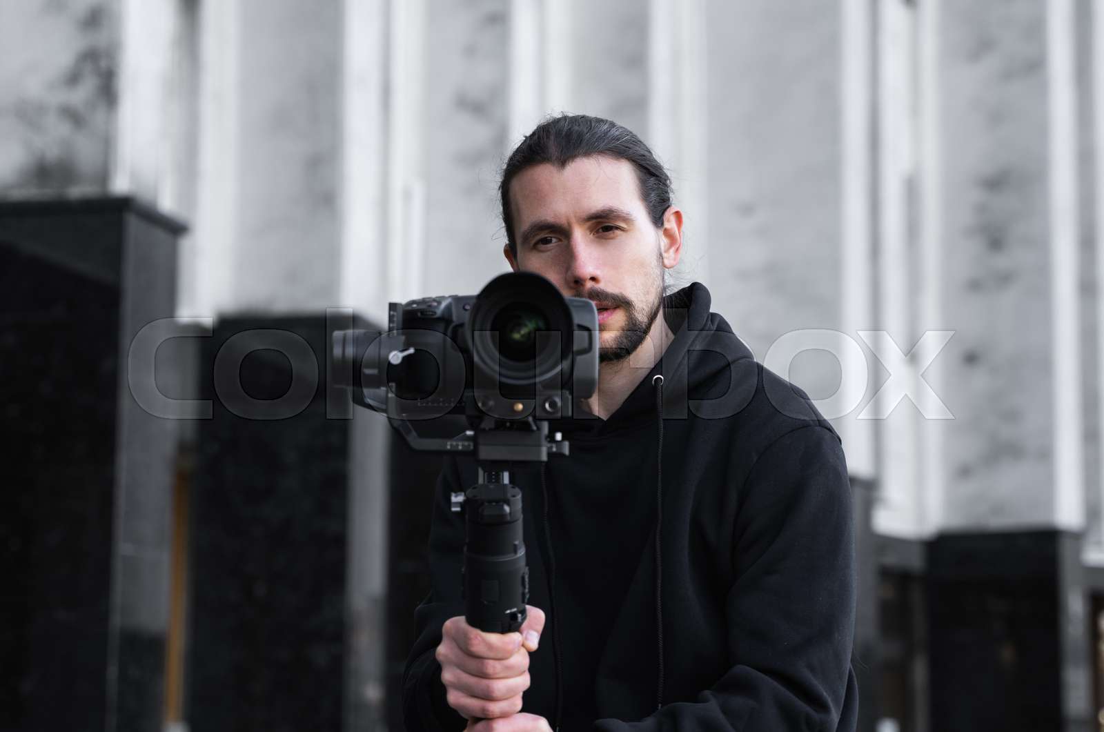 Young Professional videographer holding professional camera on 3-axis ...