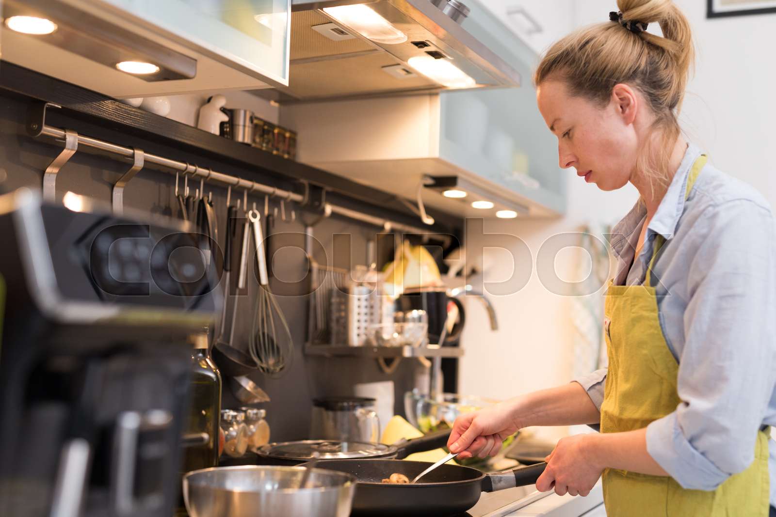 Stay at home housewife woman cooking in kitchen, salting dish in a ...