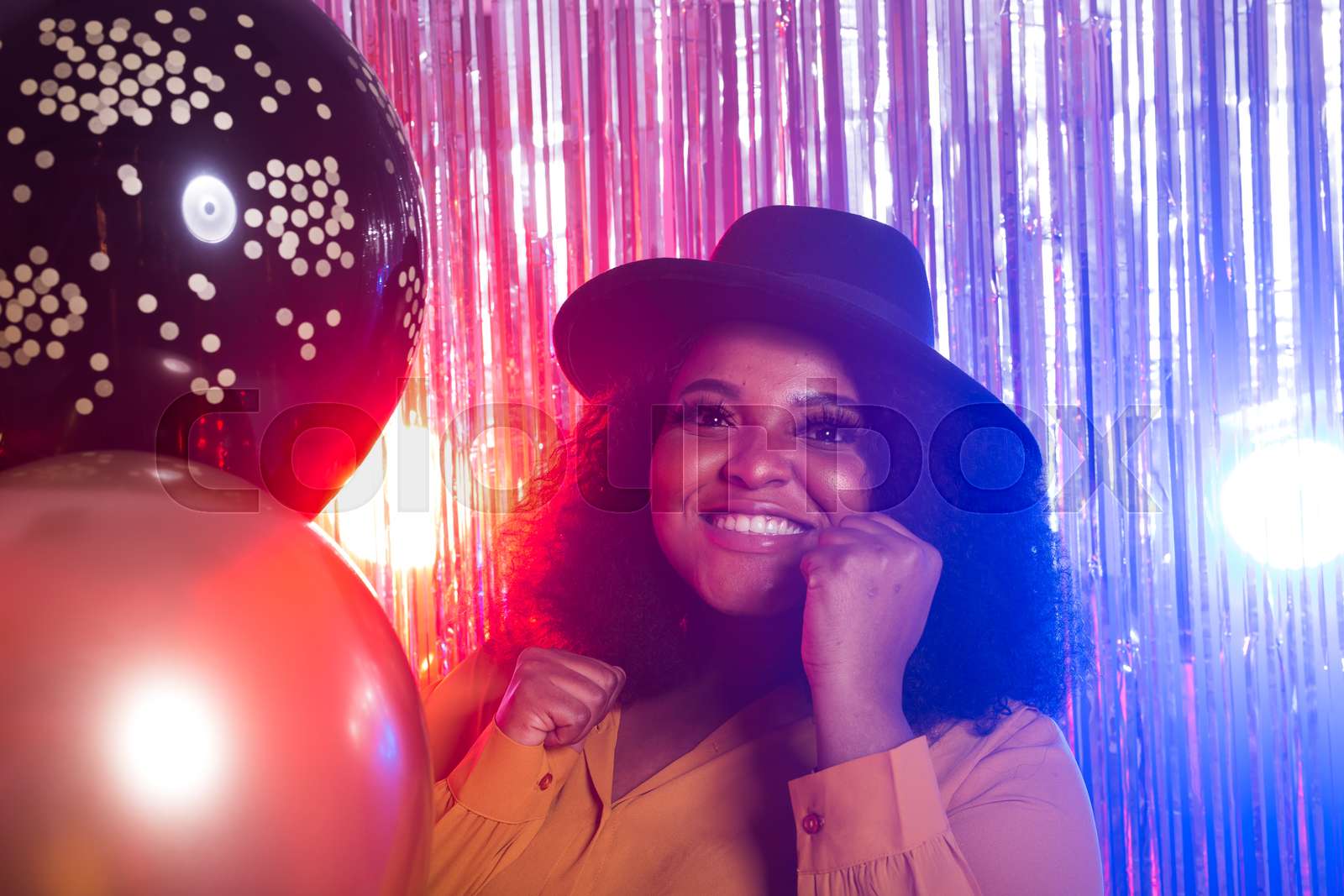 Young black woman looks happy while spend time in night club. Birthday ...