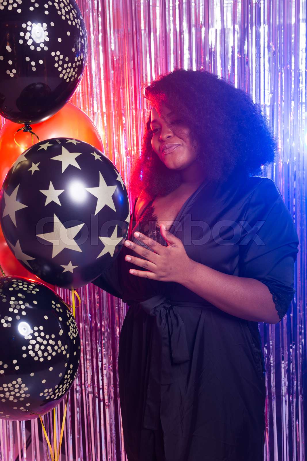 Young black woman looks happy while spend time in night club. Birthday ...