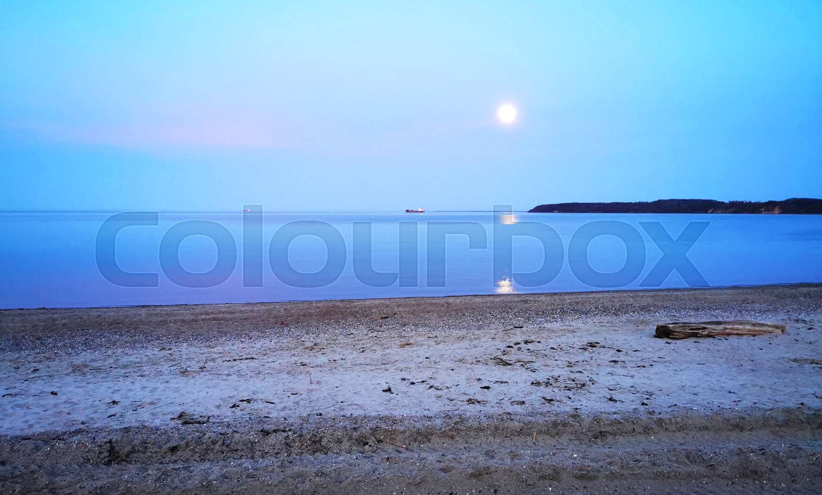 Fuldmåne over vandet og blå himmel ved strand i Fredericia en ...
