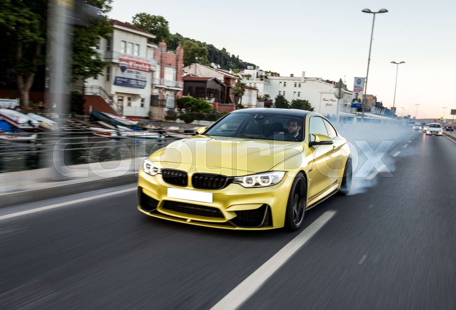Yellow sedan car on the city roads,front view | Stock image | Colourbox