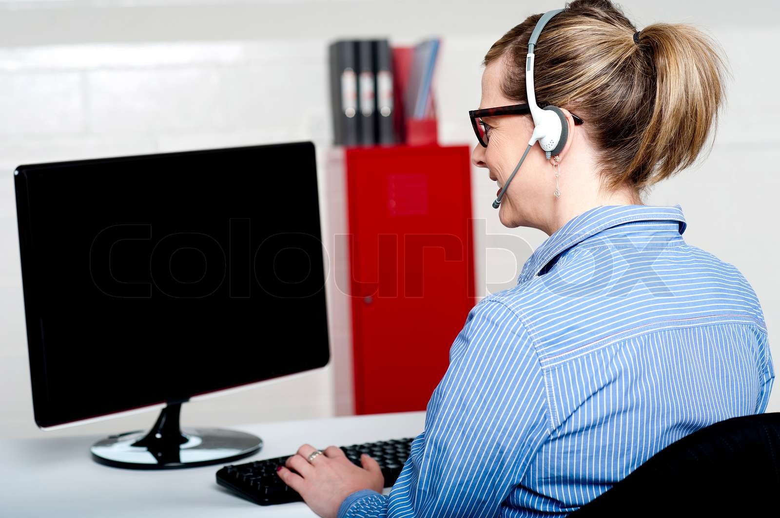 Back view of help desk lady working | Stock image | Colourbox
