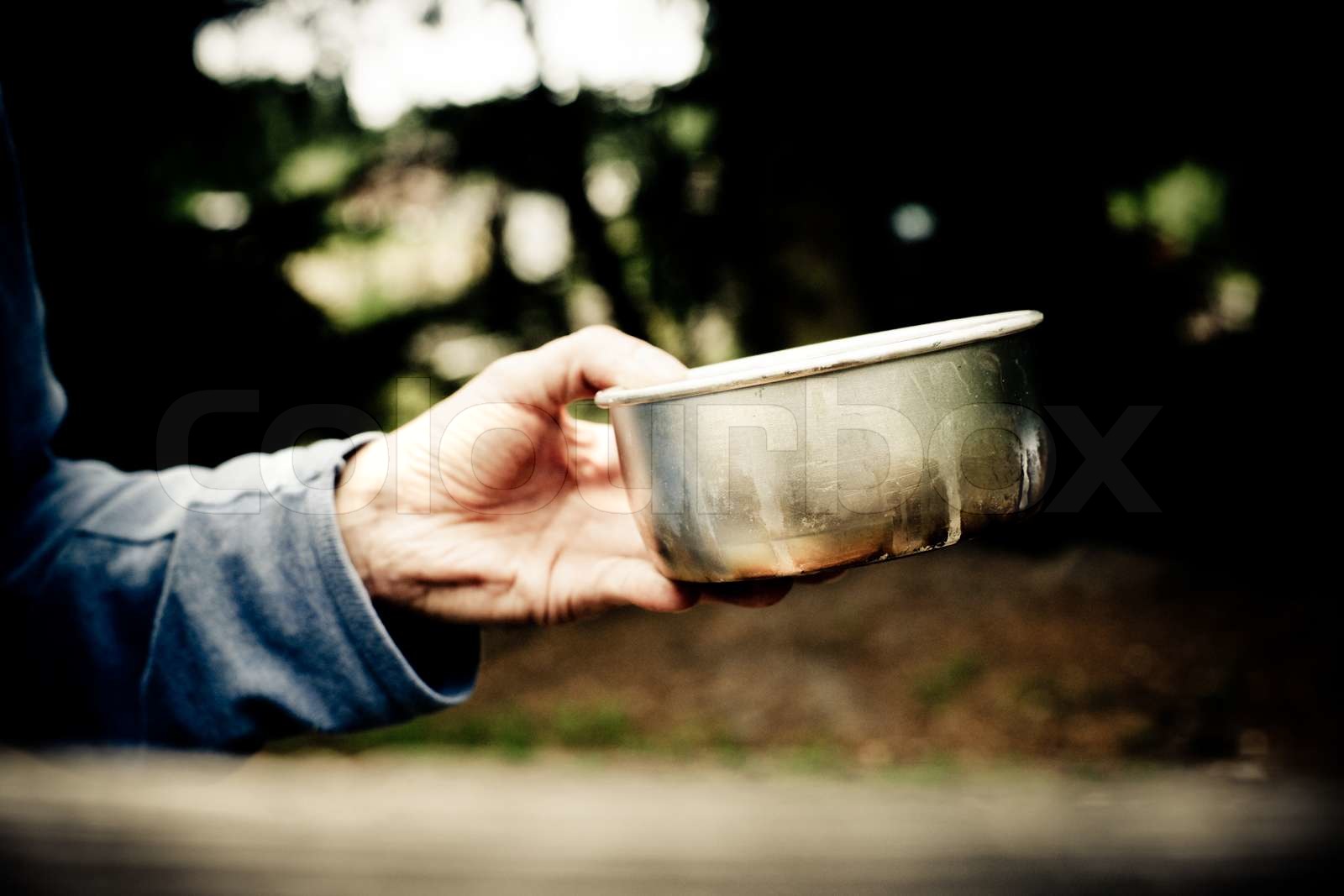 Beggar holding a tin cup | Stock image | Colourbox