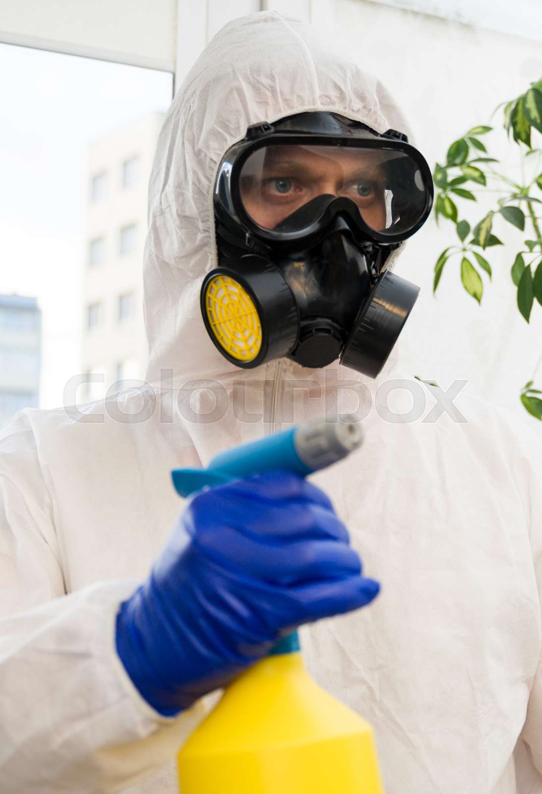 Cleaner in biohazard suit disinfecting room. | Stock image | Colourbox