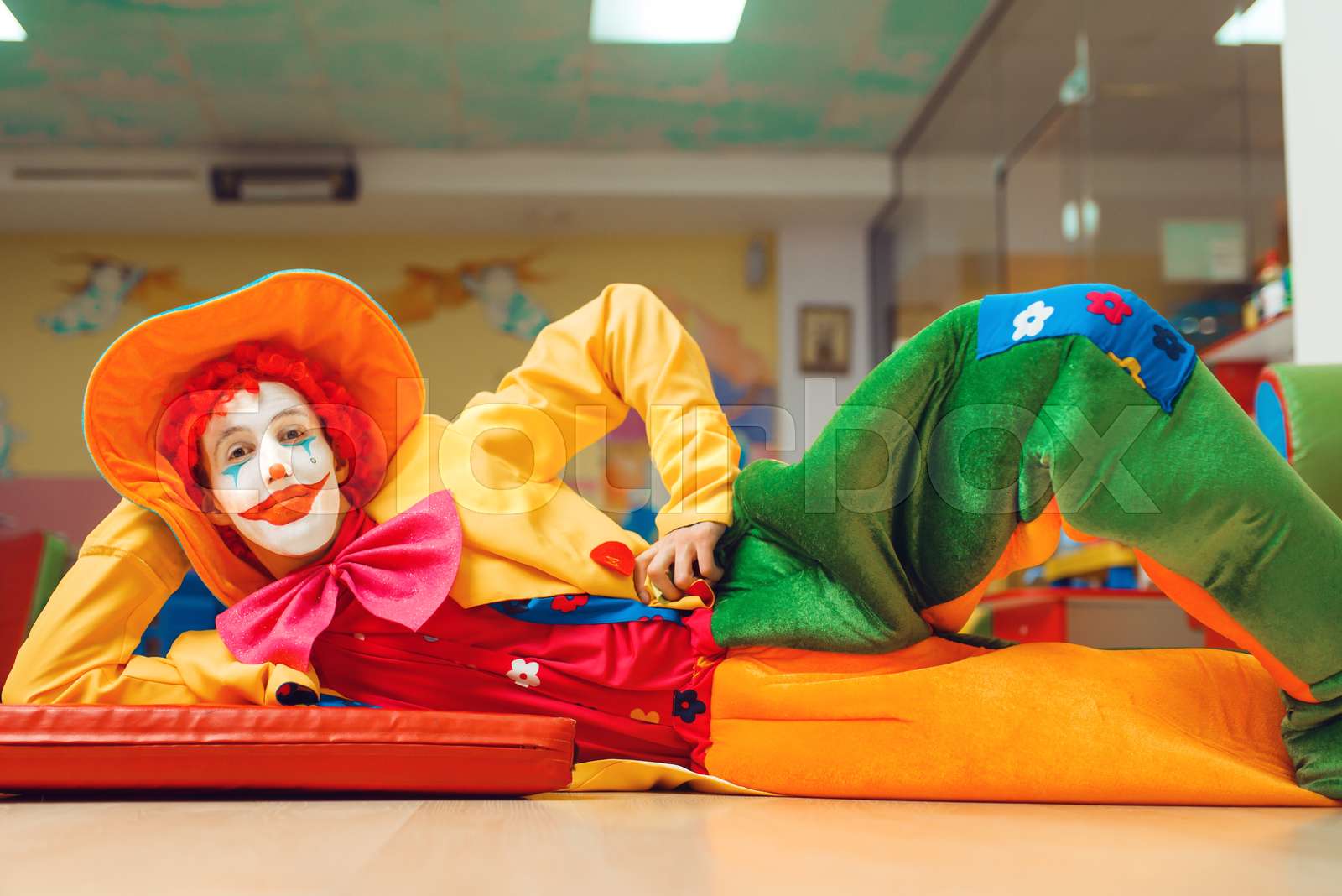 Funny clown in costume lying on the floor | Stock image | Colourbox
