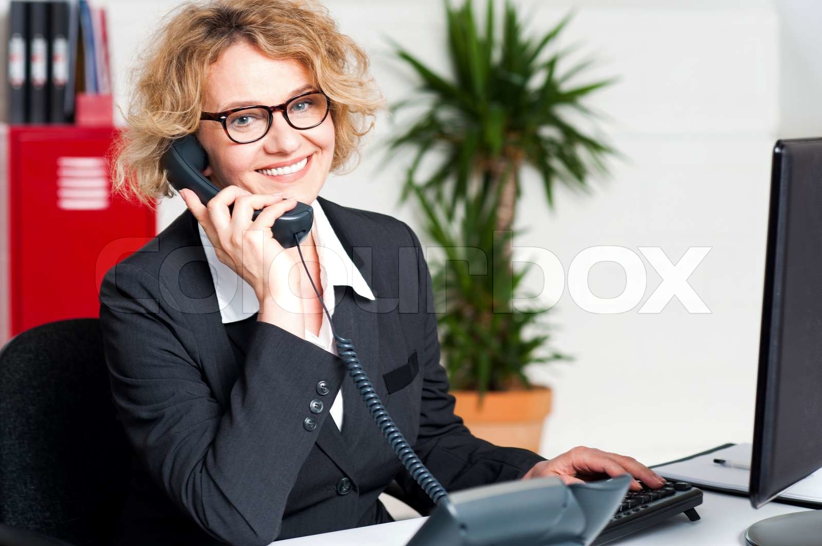 Front desk lady attending clients call | Stock image | Colourbox