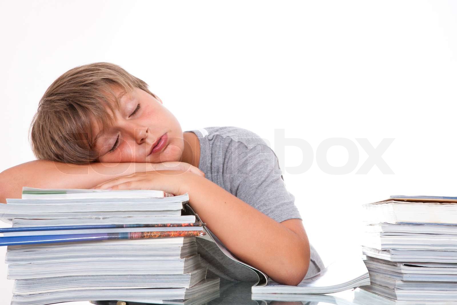 Tired student at the desk, isolated on white | Stock image | Colourbox
