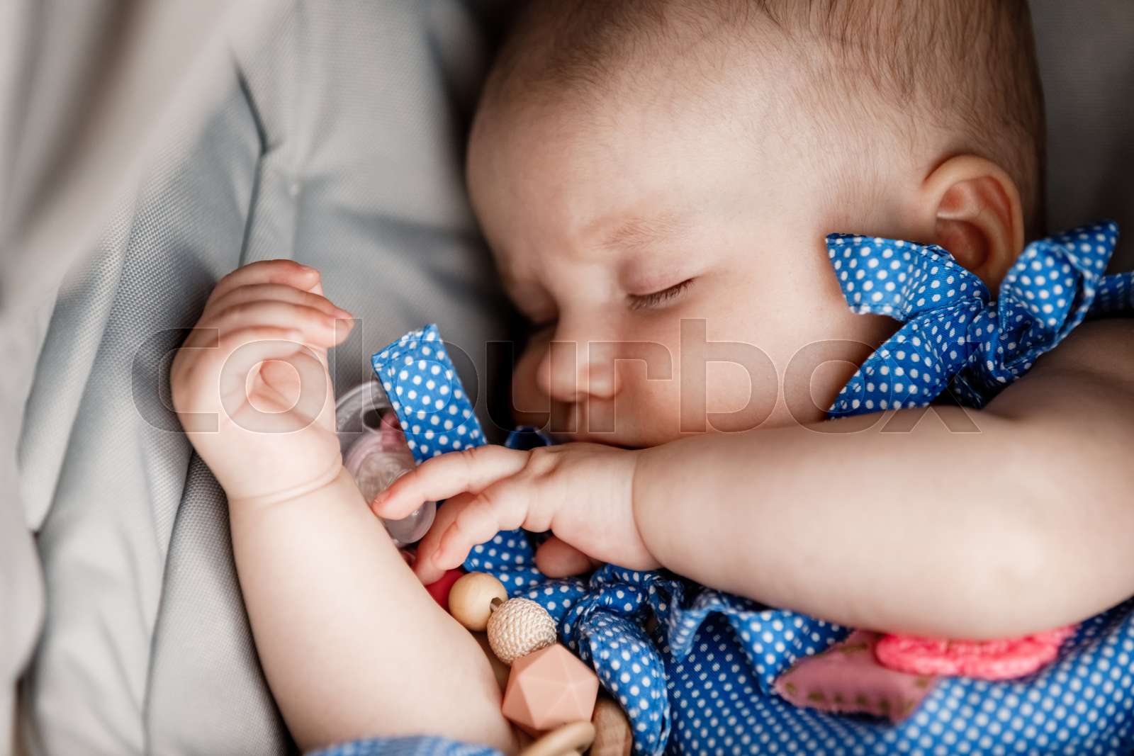 Portrait of slipping cute adorable baby girl in blue polka dot dress ...