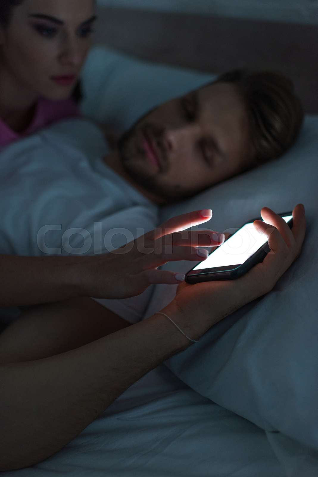 Selective focus of woman taking smartphone from sleeping boyfriend on ...