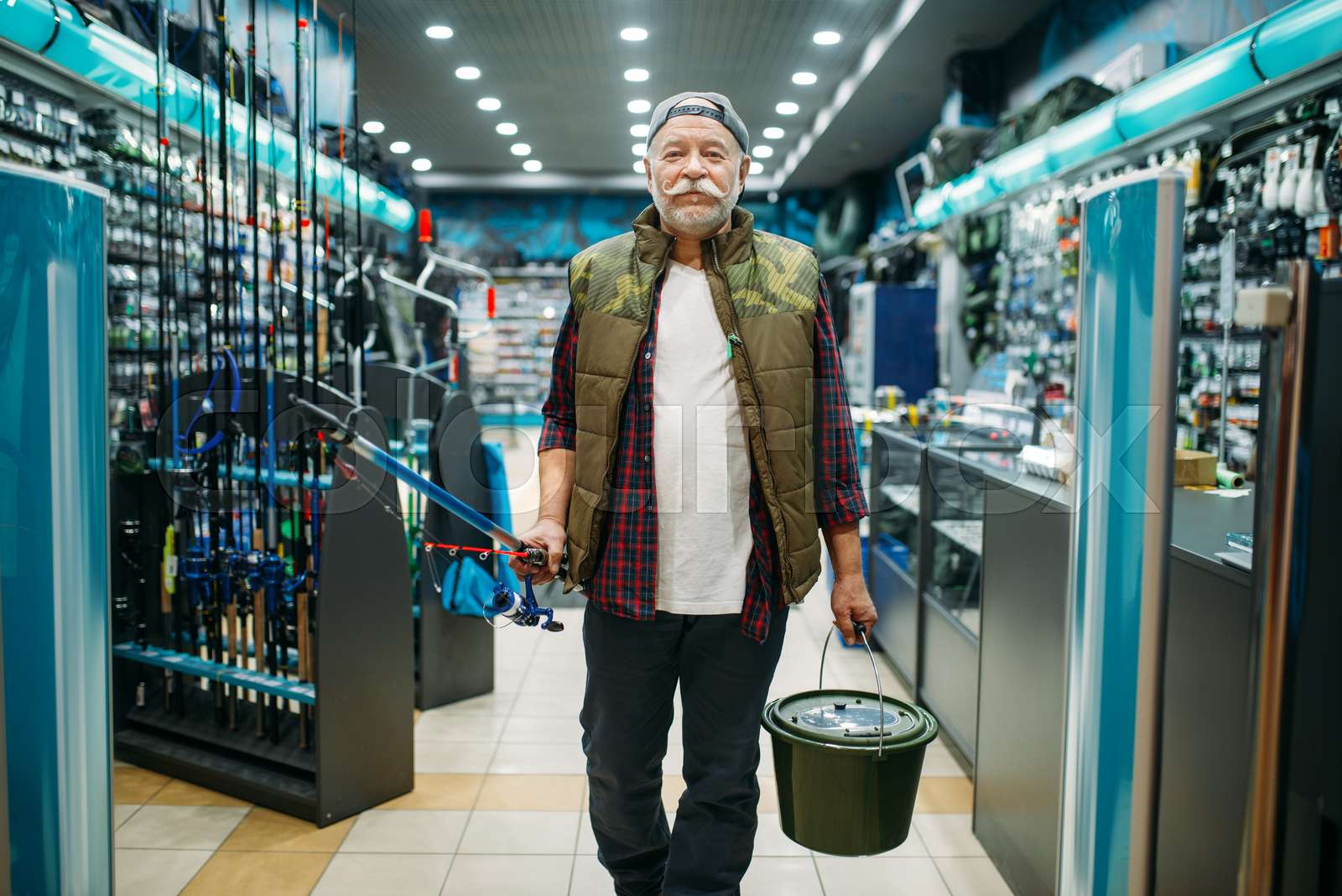Fisherman with rod and bucket in fishing shop | Stock image | Colourbox