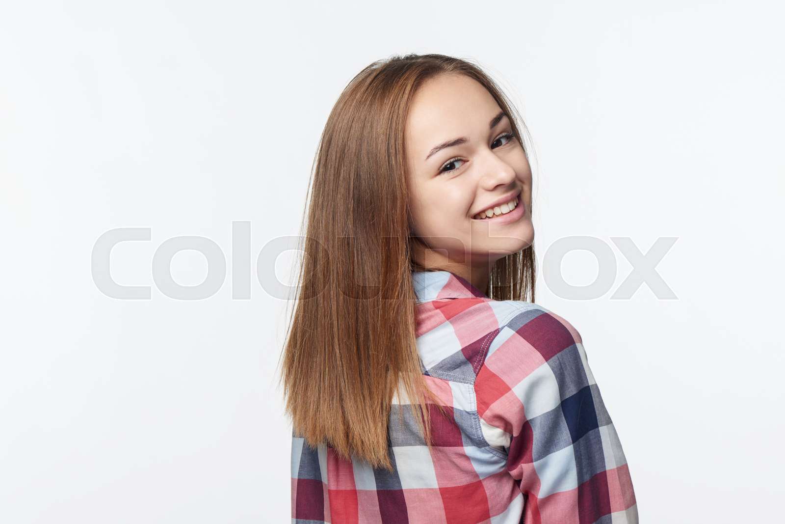 Smiling relaxed teen girl looking at camera over shoulder | Stock image ...