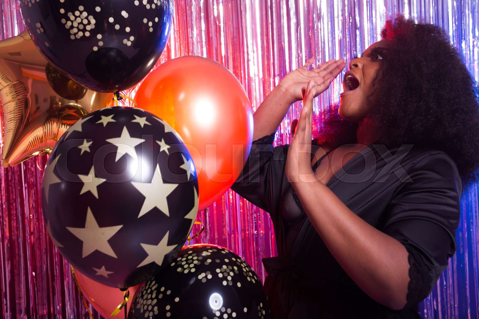 Young black woman looks happy while spend time in night club. Birthday ...