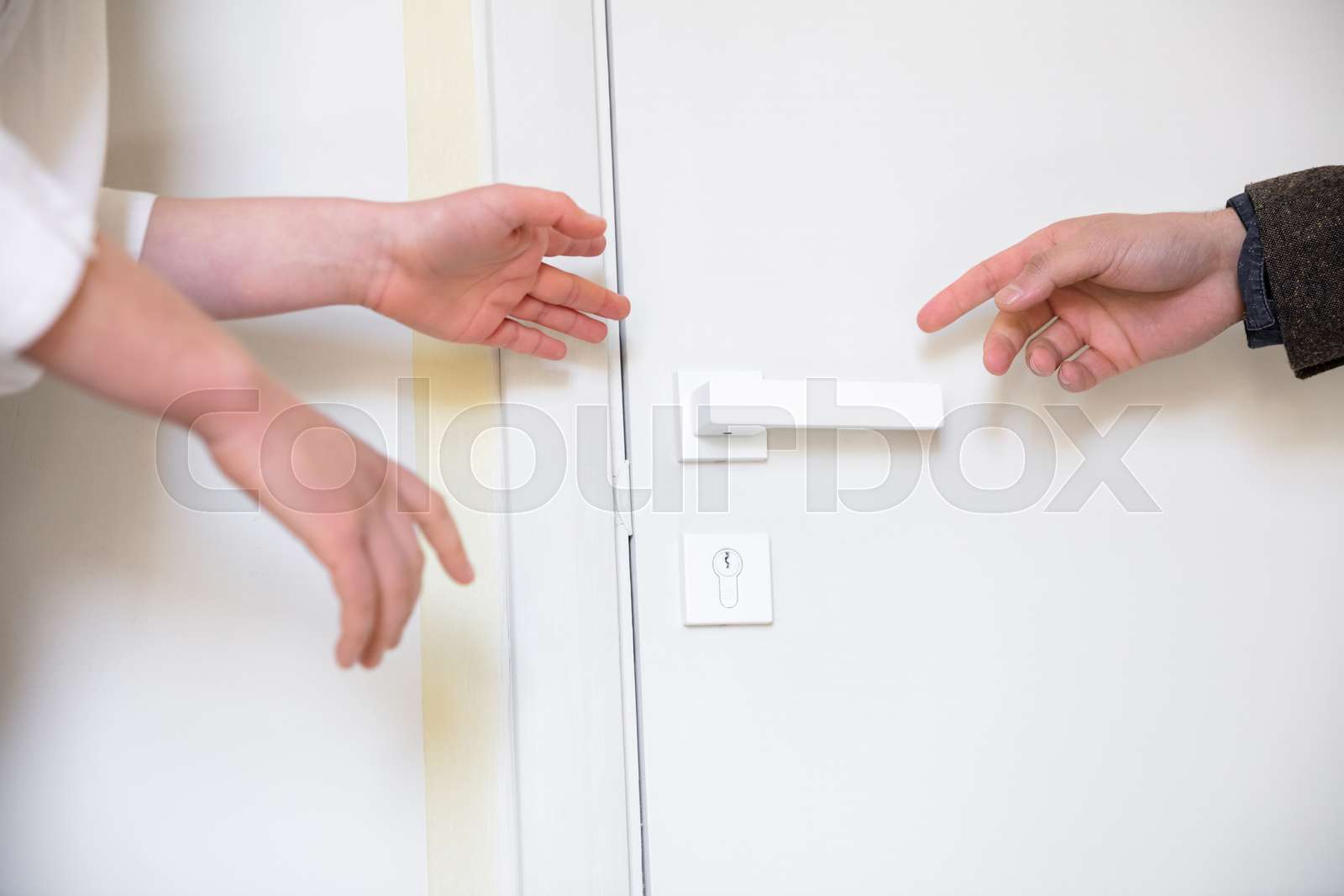 Man and woman holding handle to lock the white door, knob | Stock image ...