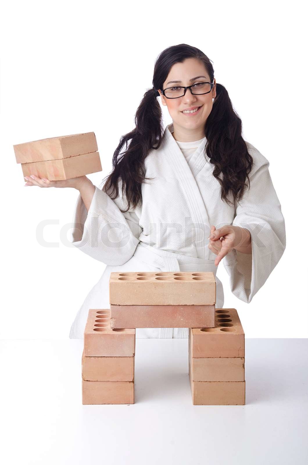 Woman karate breaking bricks on white | Stock image | Colourbox