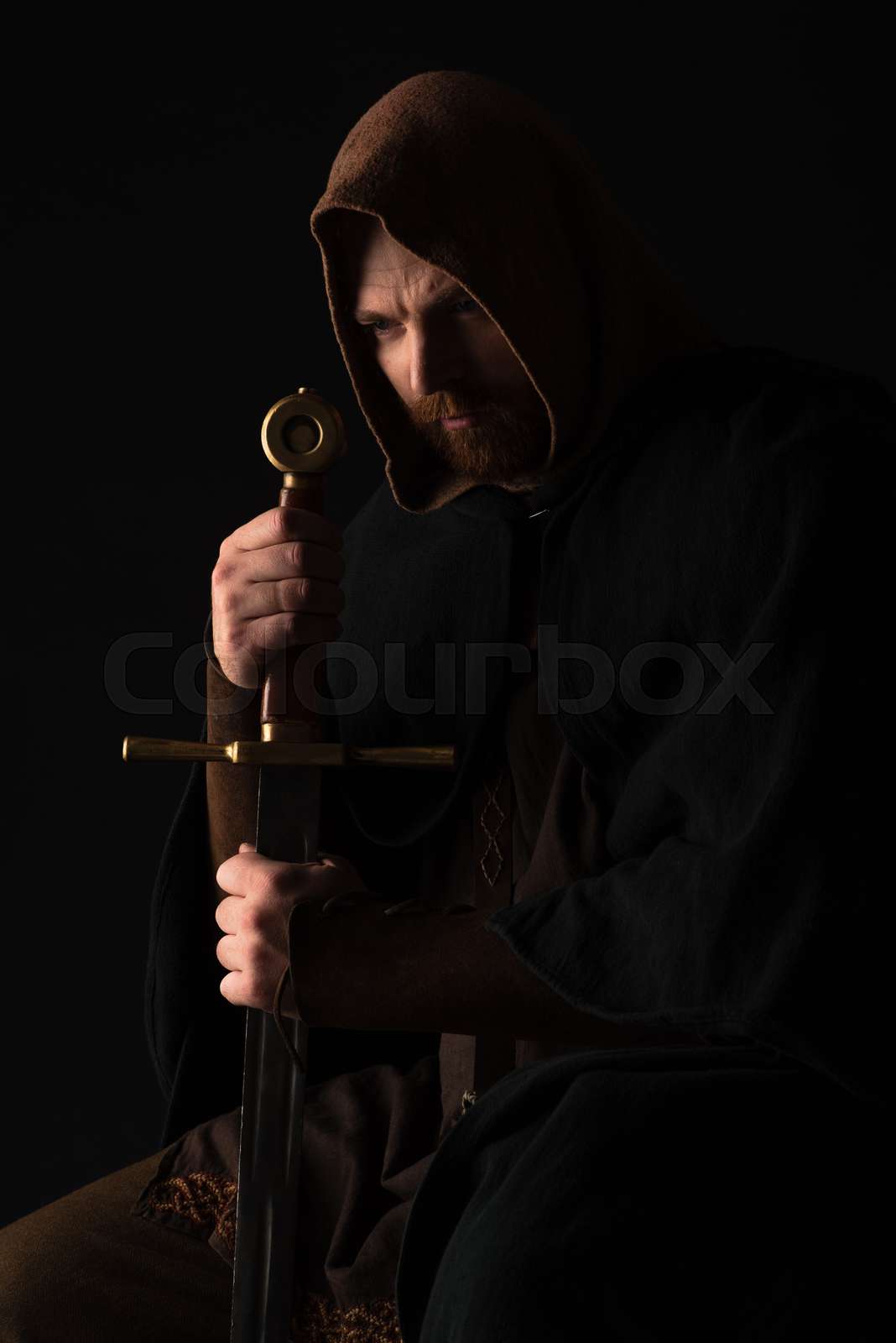 tense medieval Scottish man in mantel with sword in dark isolated on ...