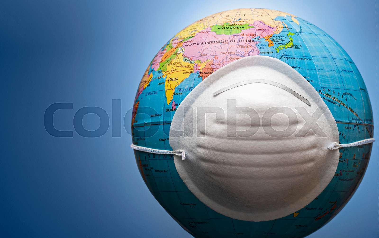 Face mask around a world globe in side view | Stock image | Colourbox