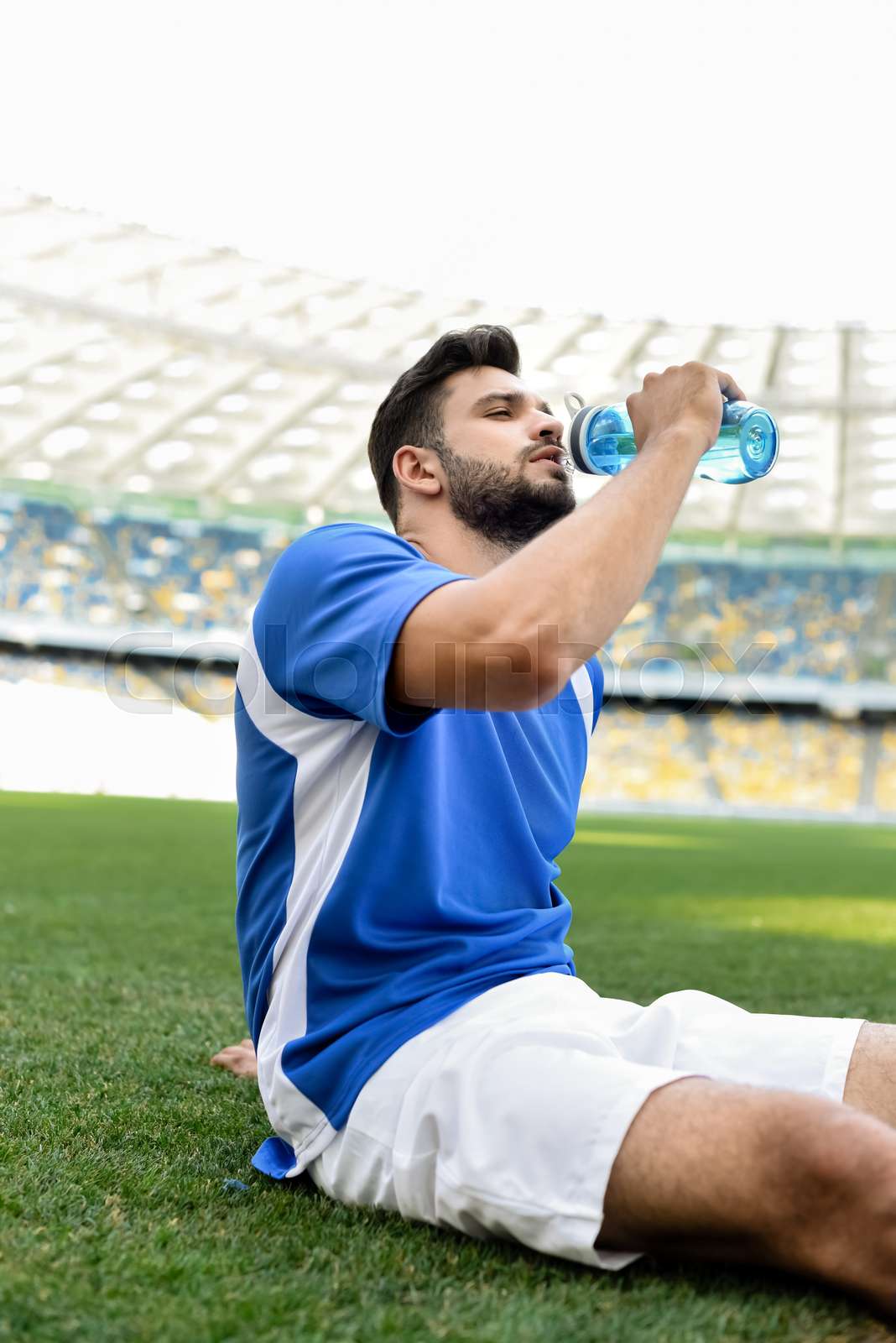 professional soccer player in blue and white uniform sitting on ...
