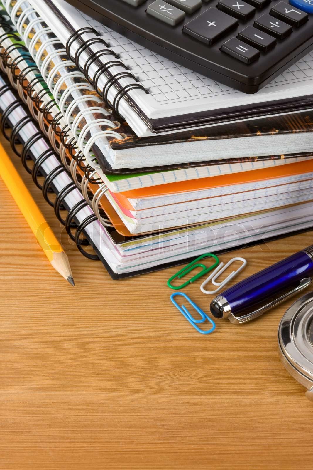 pile of notebook and pens on wood background | Stock image | Colourbox