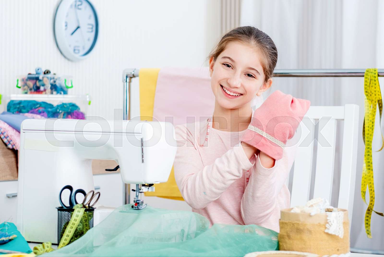 smiling little girl working at the sewing machine | Stock image | Colourbox