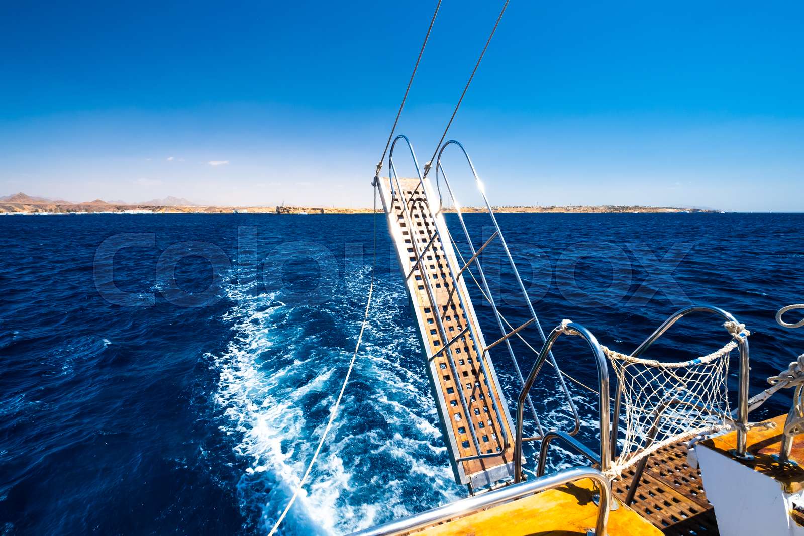 Boat alone in sea with beach at horizon | Stock image | Colourbox