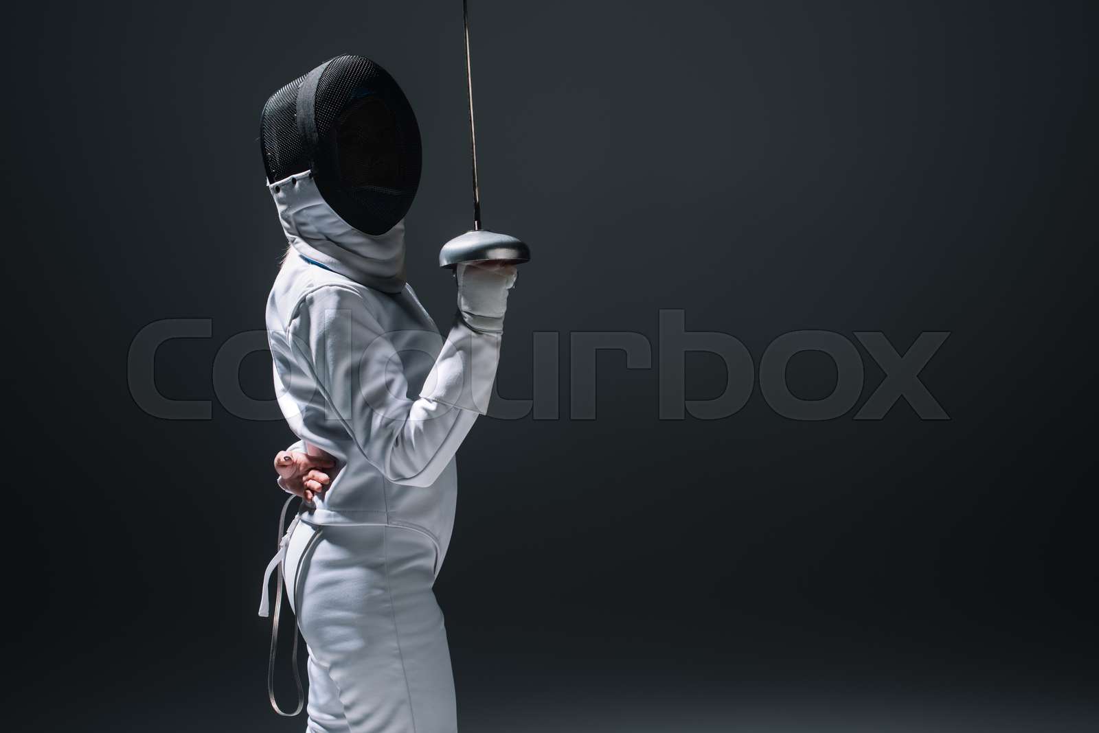 Side view of fencer holding rapier isolated on black with copy space ...