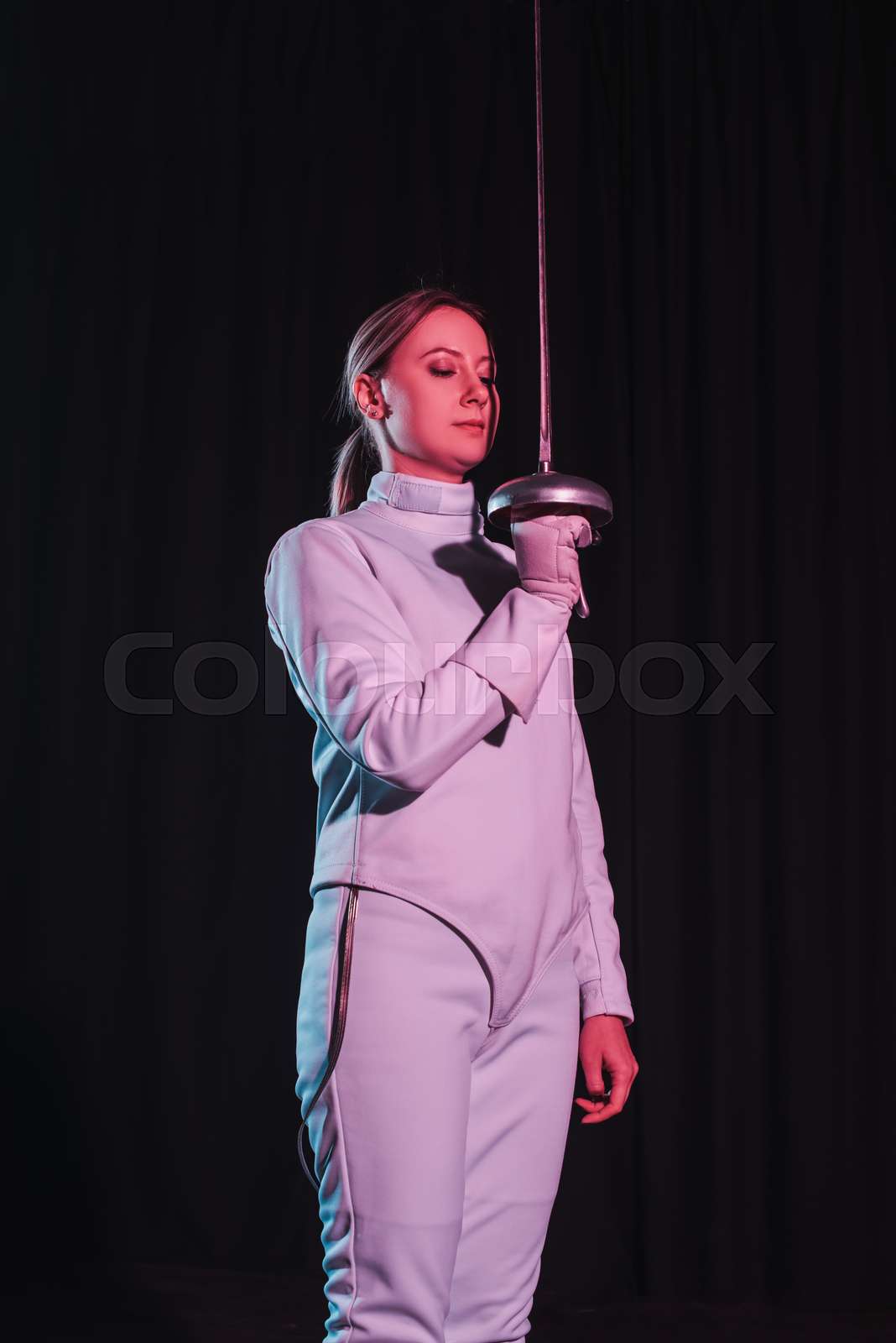Beautiful woman in fencing suit holding rapier isolated on black ...