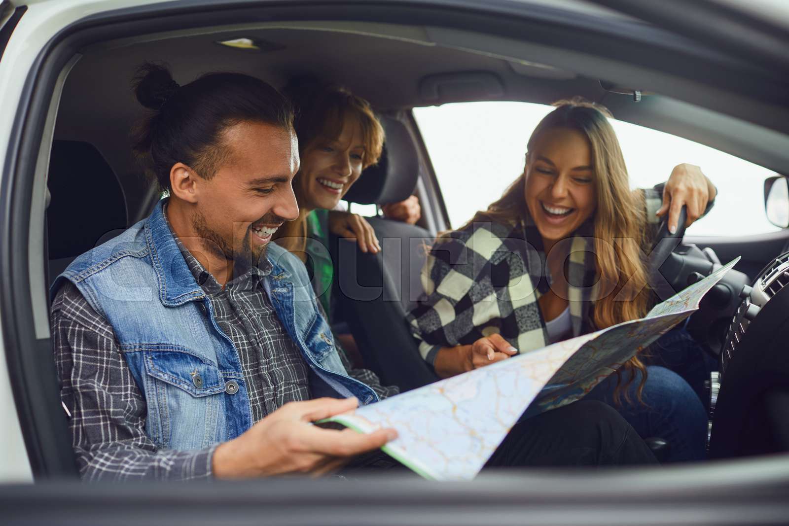 A group of friends choose the route on the map ride in the car. | Stock ...