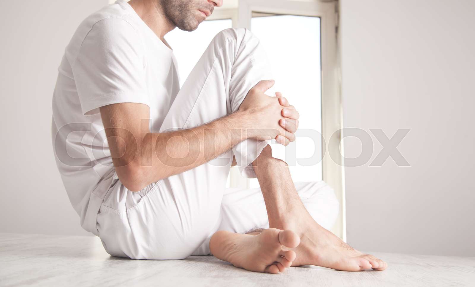 Caucasian man suffering from leg pain. | Stock image | Colourbox