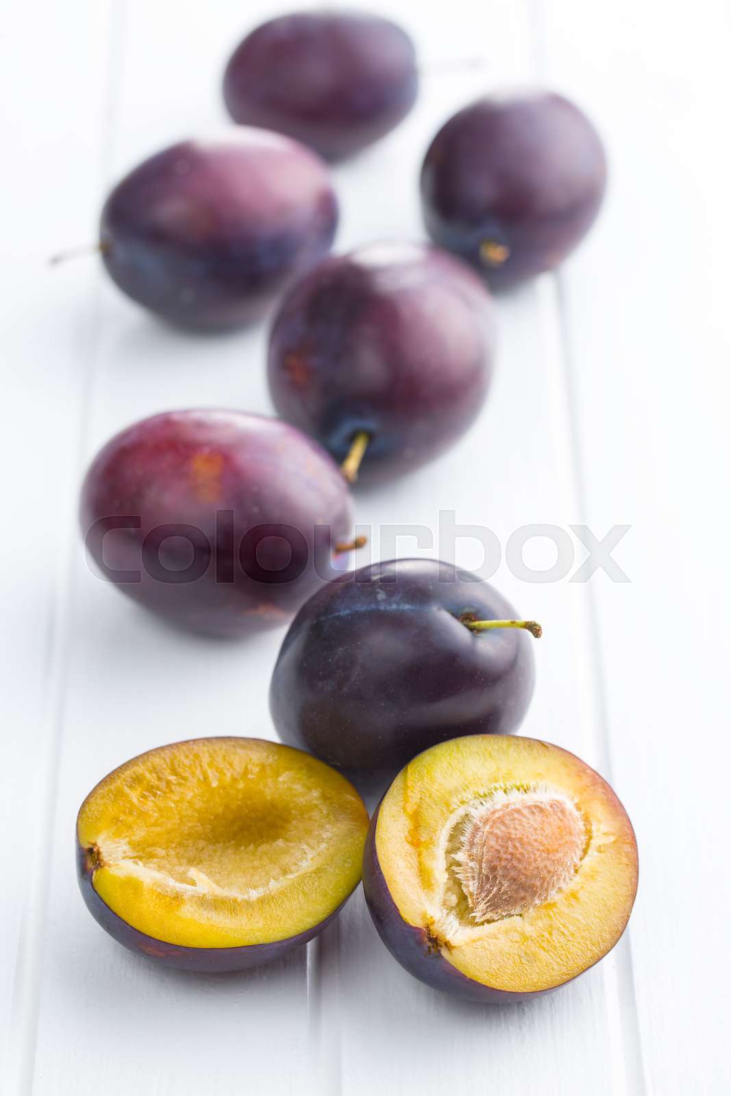 Halved ripe plum. | Stock image | Colourbox