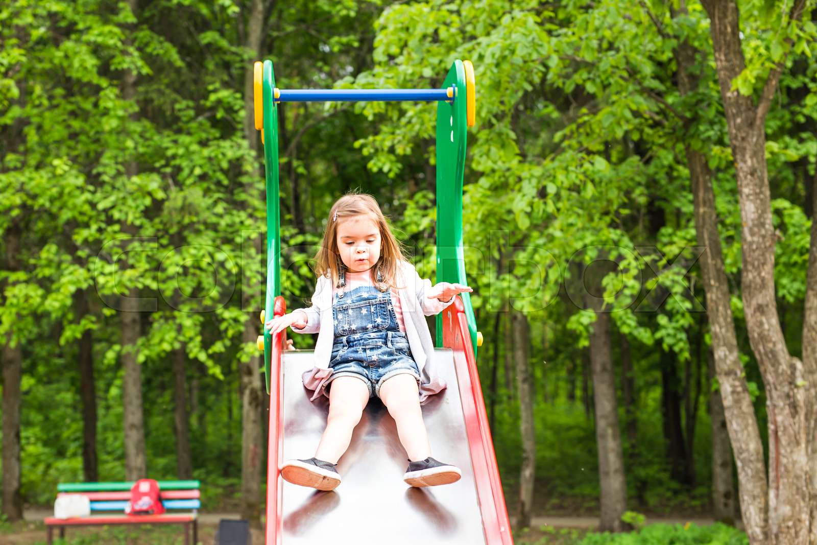 Happy kids playing on slide at school playground | Stock image | Colourbox