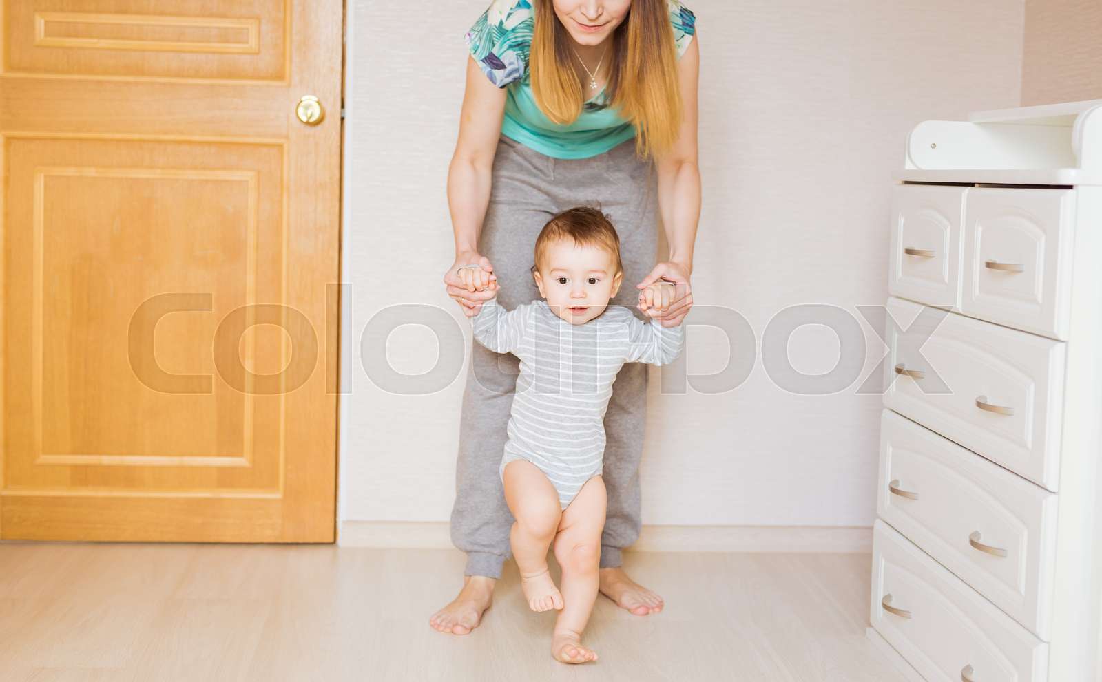 baby taking first steps with mother help | Stock image | Colourbox