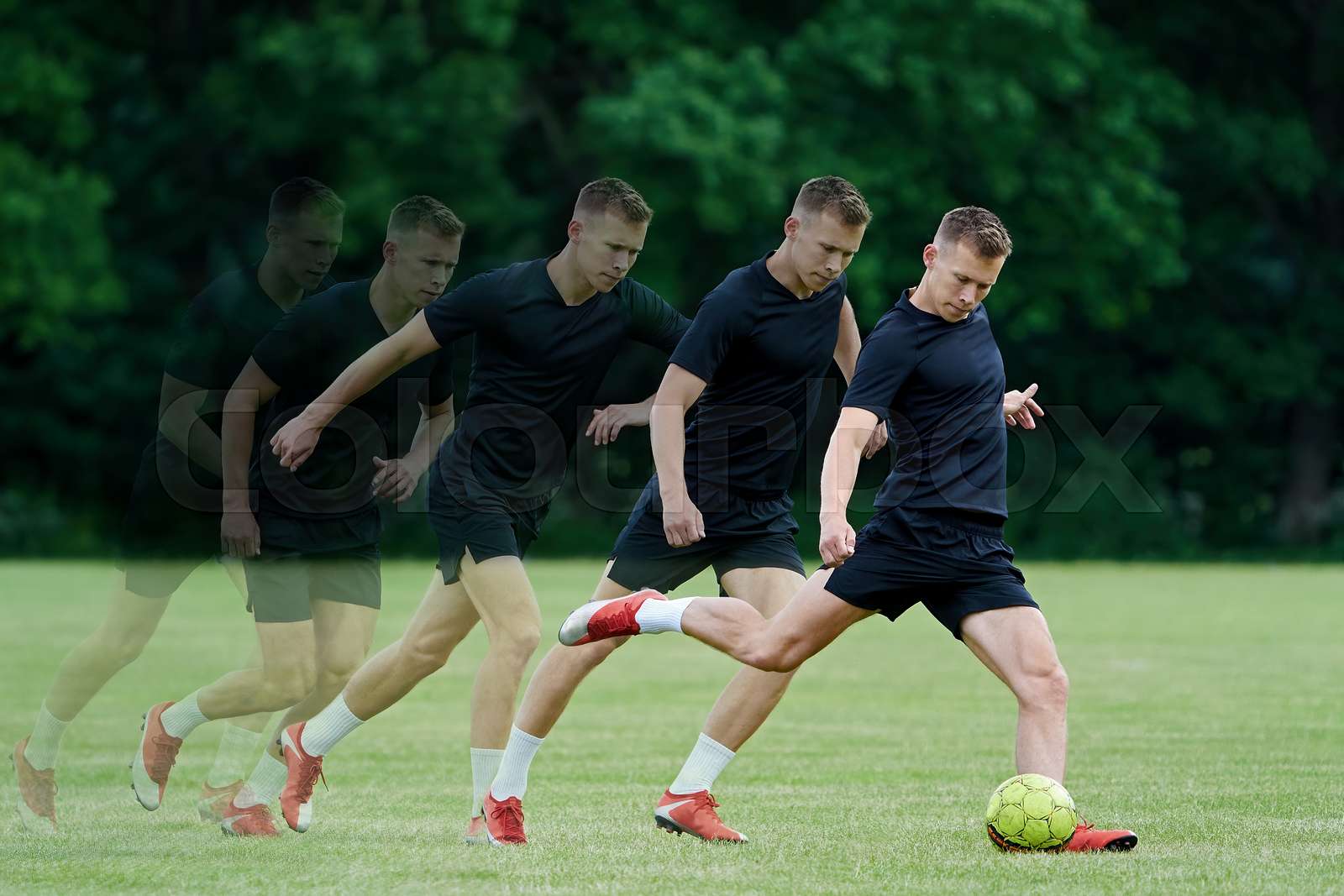 Football player kicking a ball in multiple exposures | Stock image ...