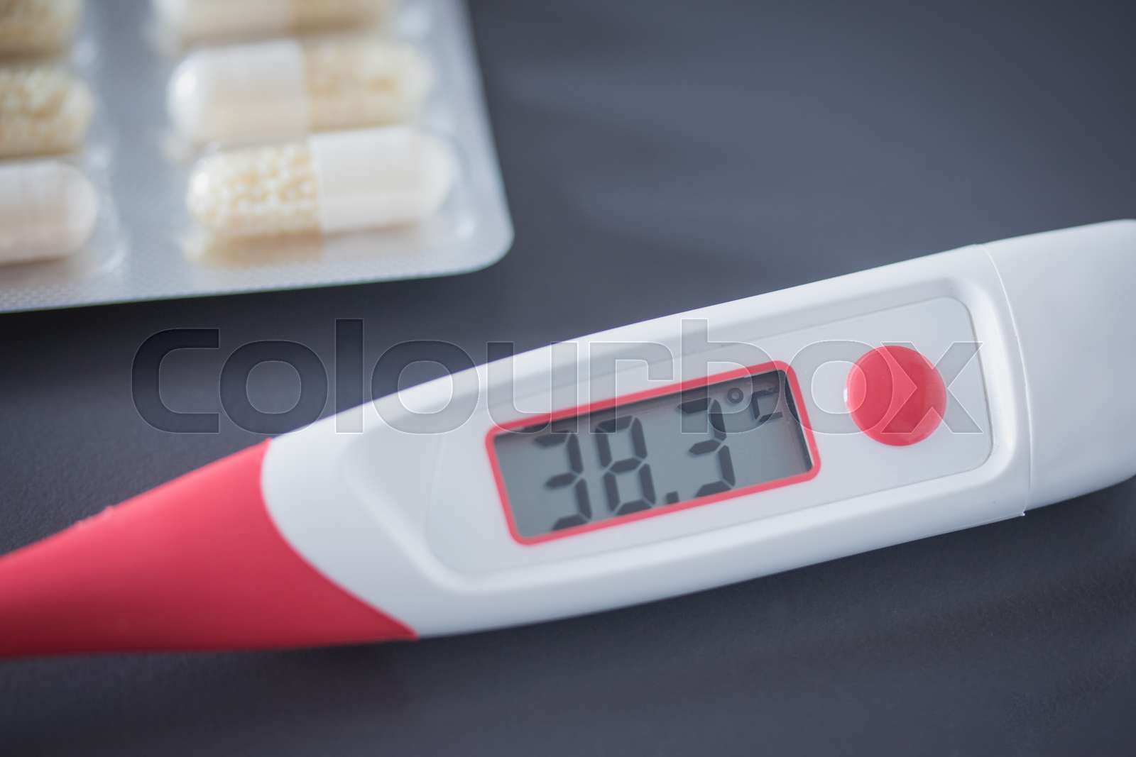 Fever thermometer and pills on the desk, 38 degrees Celsius on the ...