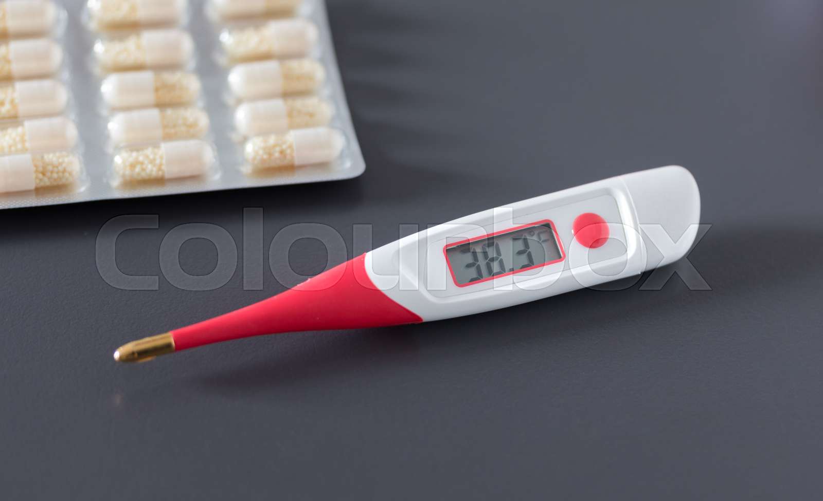 Fever thermometer and pills on the desk, 38 degrees Celsius on the ...