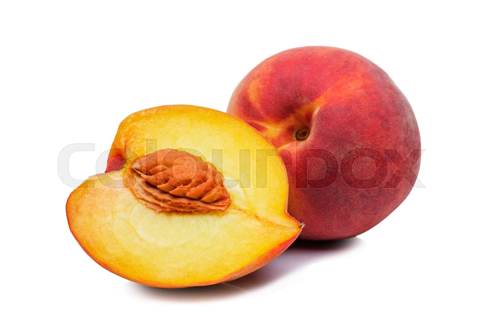 Whole and halved fresh peach showing the pip | Stock image | Colourbox