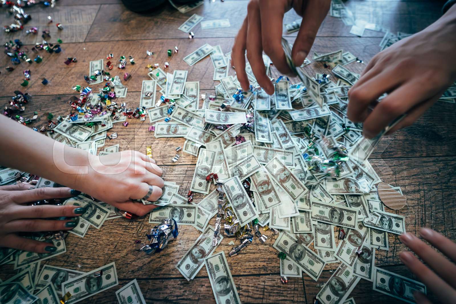 Several pairs of hands pick up dollar bills from the floor | Stock ...
