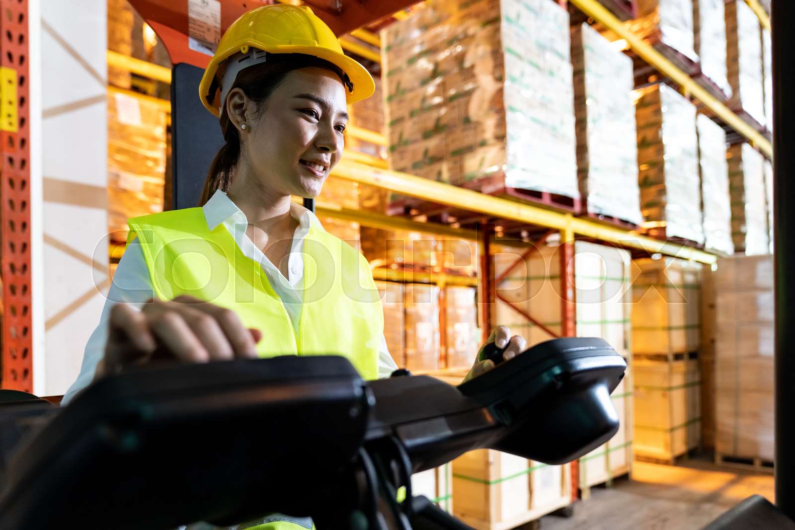 Asian warehouse worker with forklift in warehouse | Stock image | Colourbox