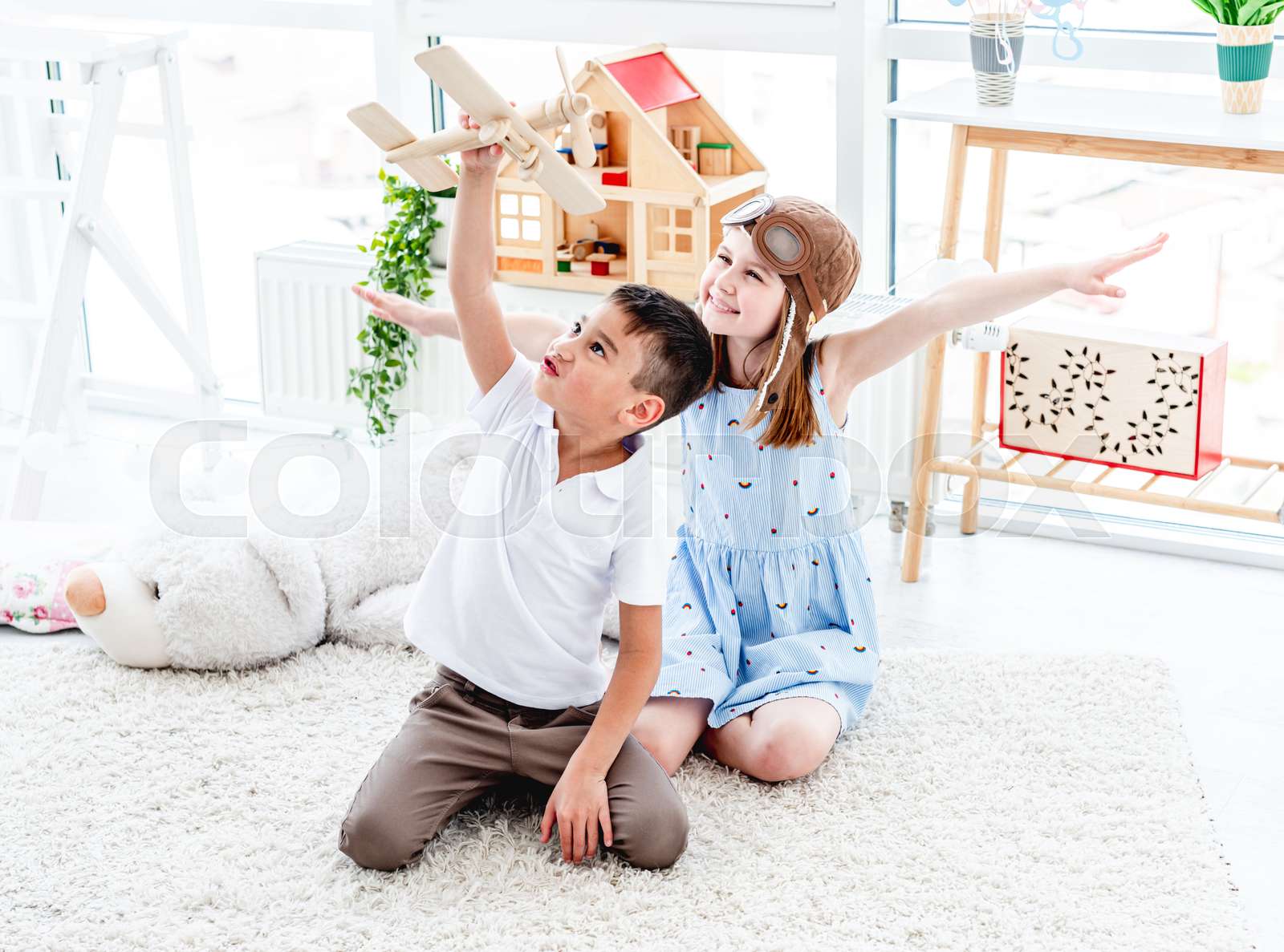 Smiling little friends flying wooden plane | Stock image | Colourbox