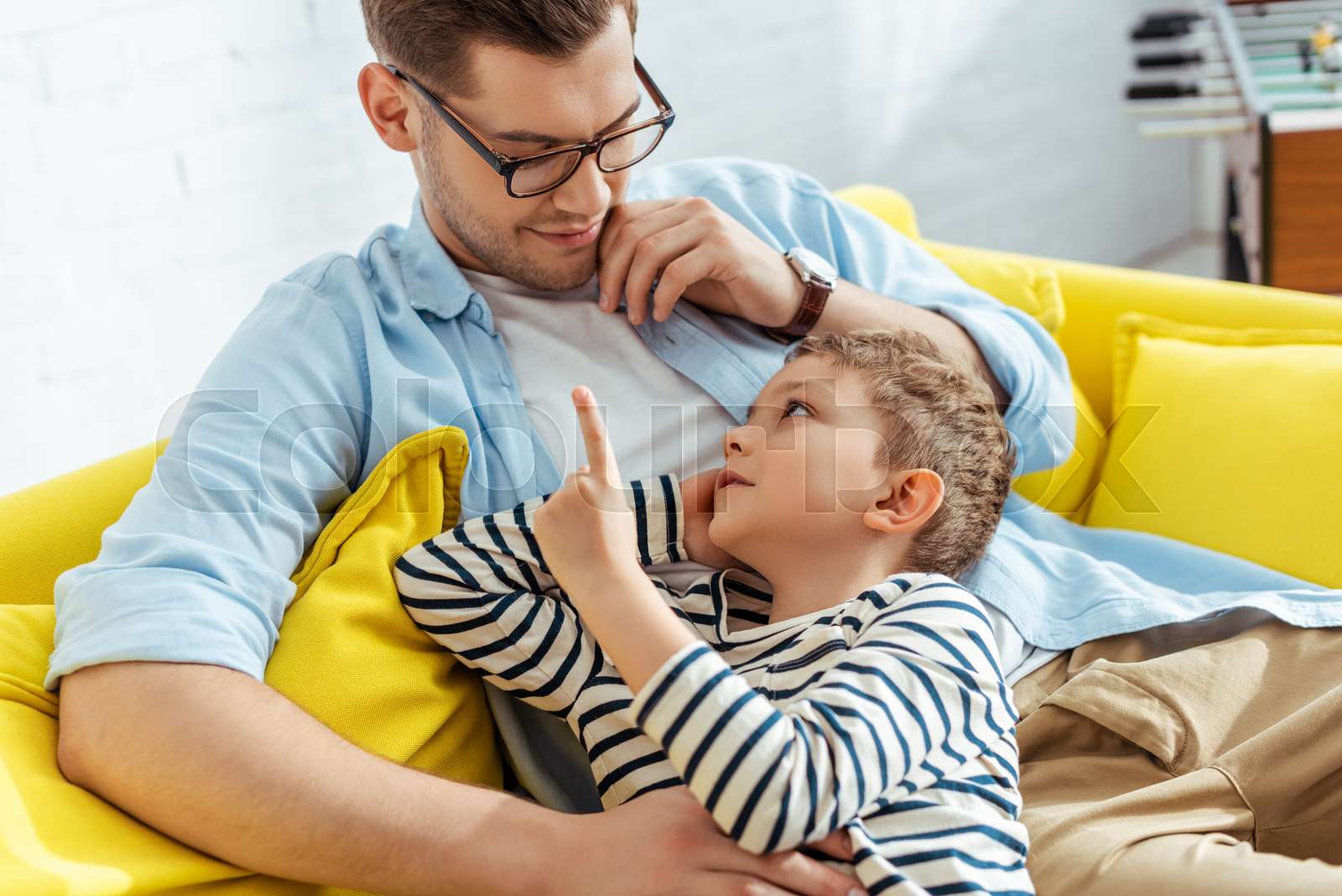 adorable kid showing idea gesture while talking to smiling father ...
