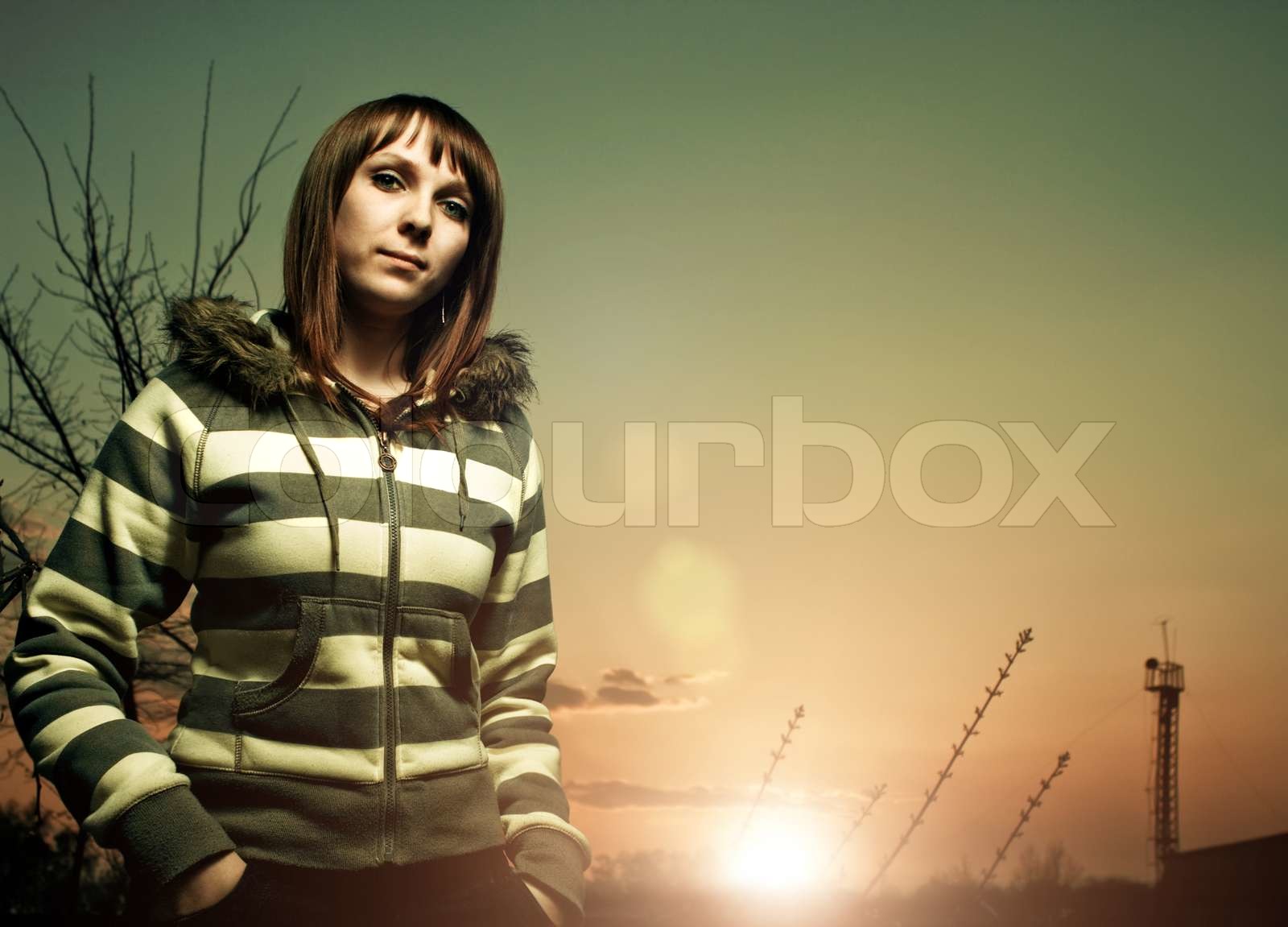 young girl looking into camera with sunset behind her | Stock image ...